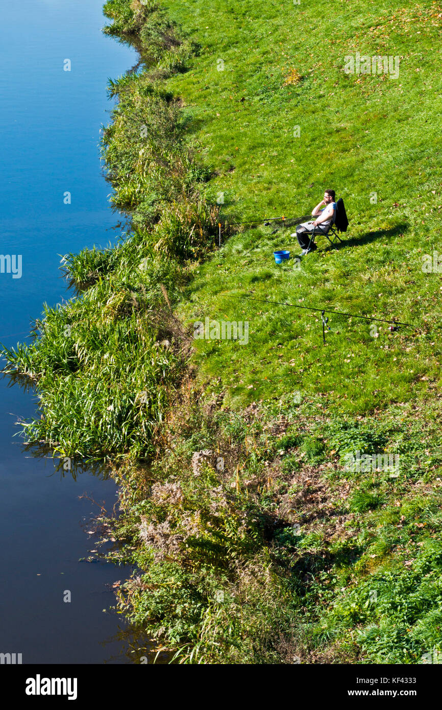fisherman on the bank of a river sitting on a chair Stock Photo - Alamy