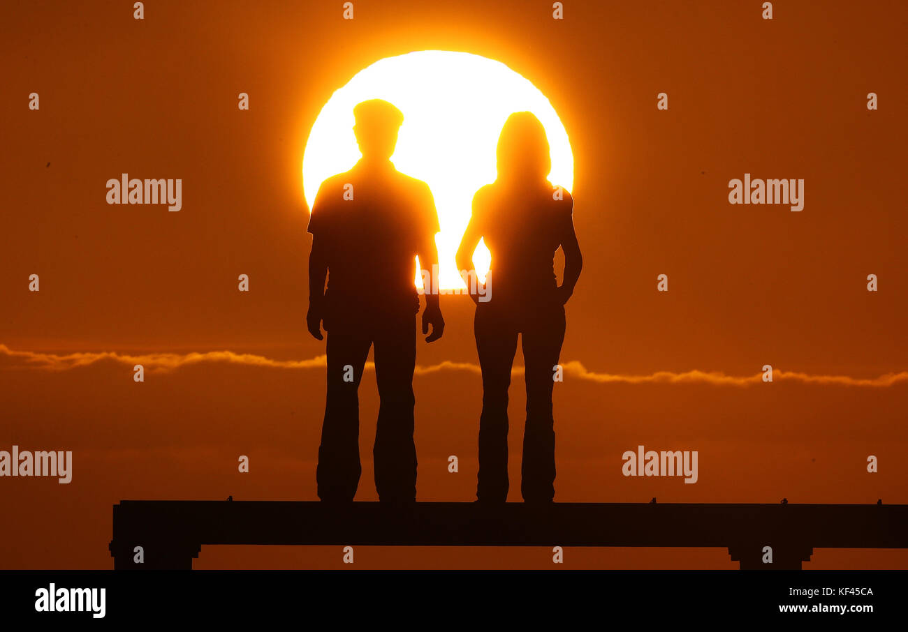 The sun rises over the Couple sculpture by Sean Henry on the North Sea ...