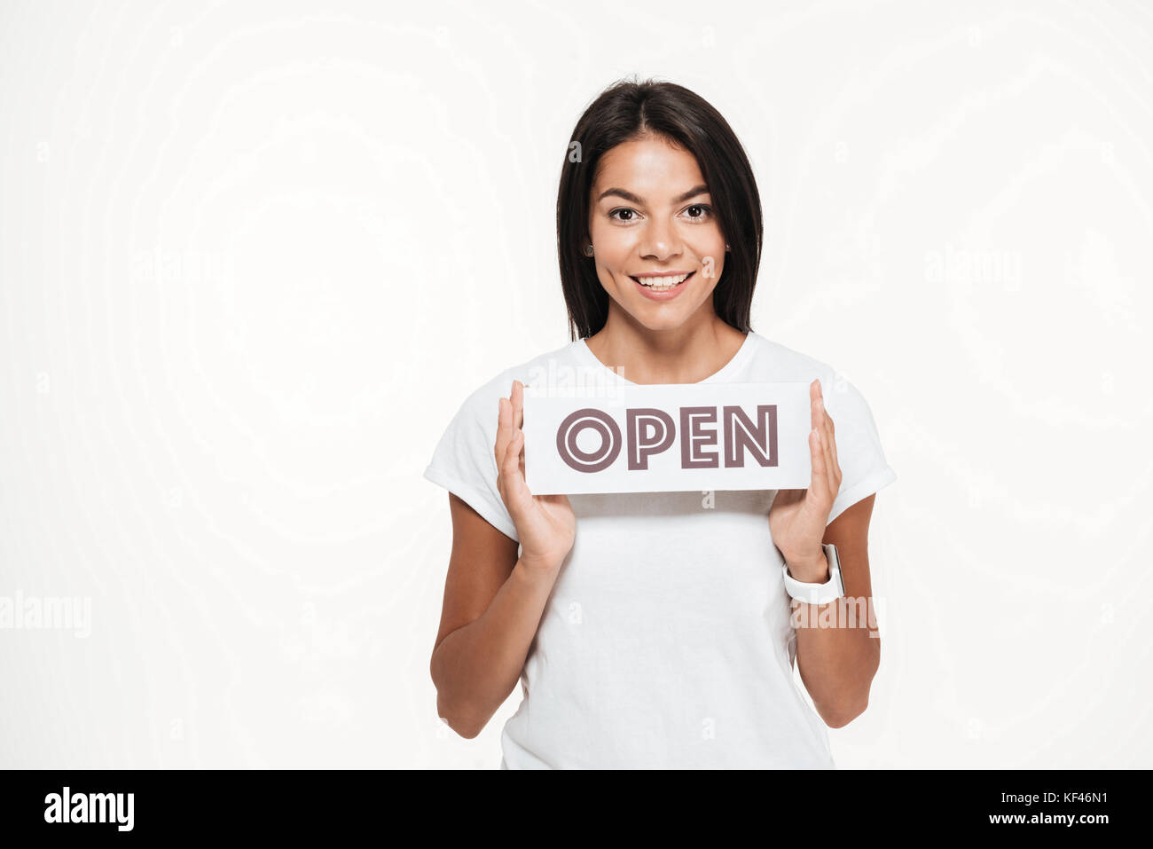 Portrait of a smiling attractive woman showing open sign isolated over ...