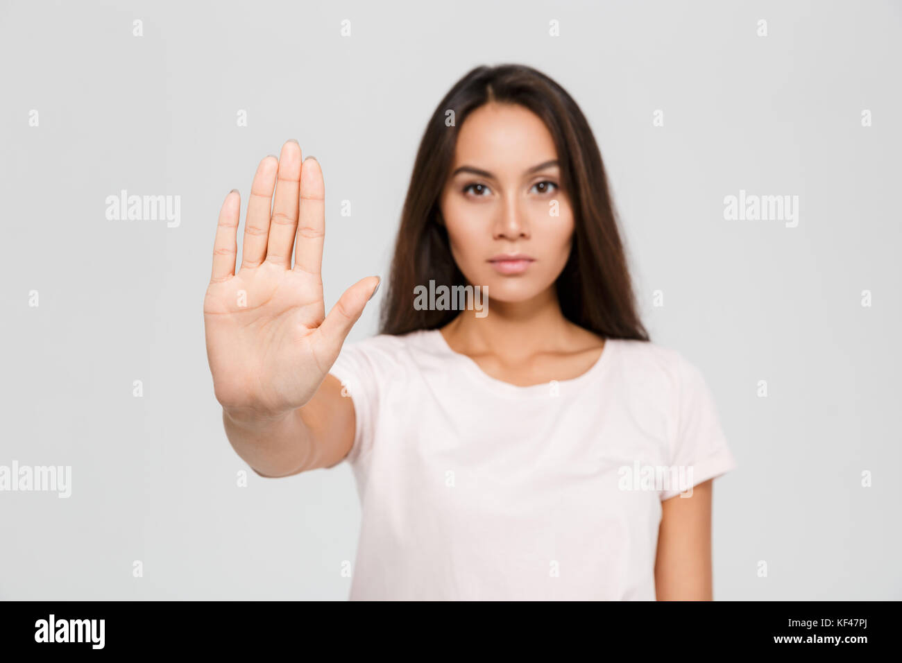 Portrait of a serious young asian woman standing with outstretched hand ...