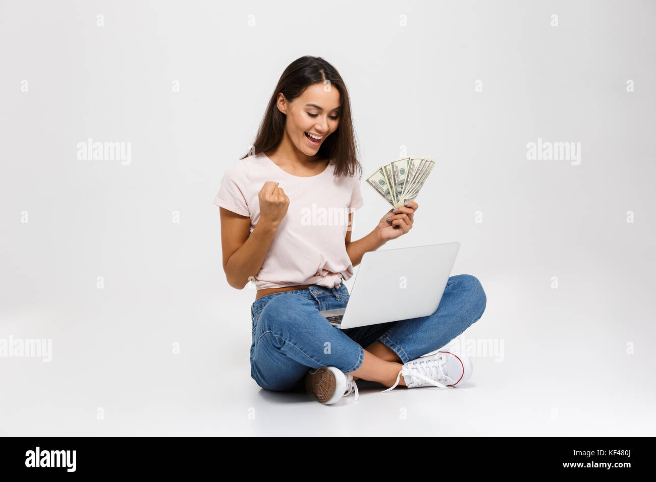 Portrait of a happy excited asian girl holding money banknotes while ...