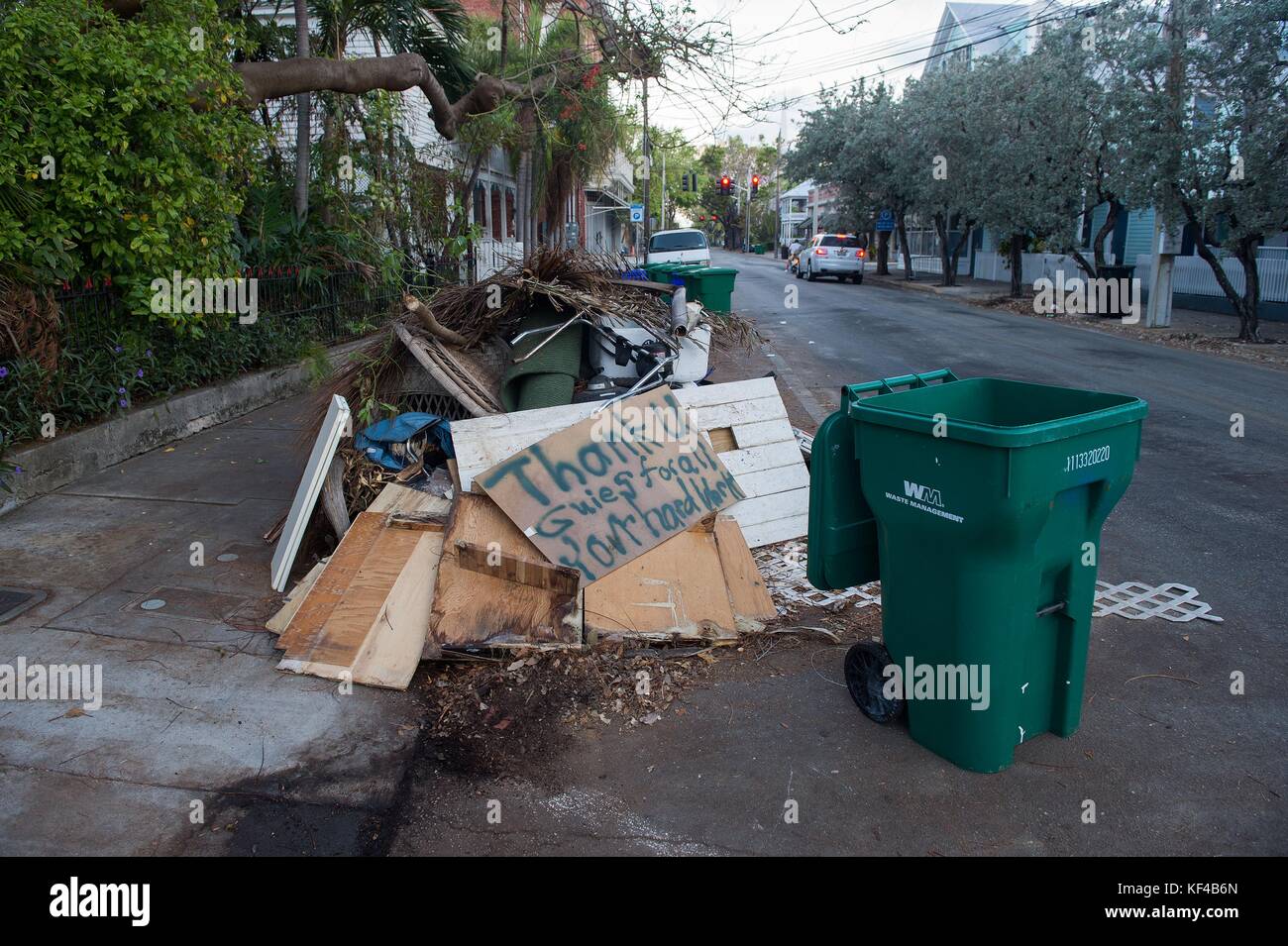 A hand-written sign thanking clean-up crews sits in front of a pile of ...