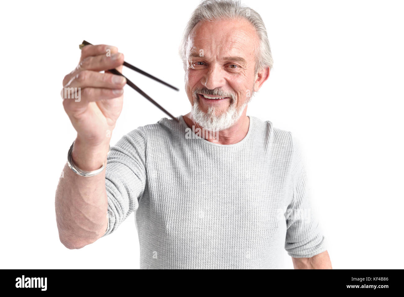 Old man holding chopsticks Stock Photo - Alamy