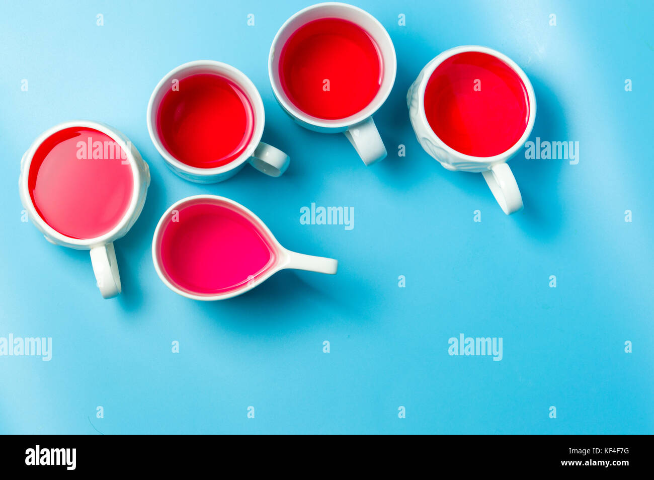 Red herbal tea in cups on blue background top view Stock Photo - Alamy