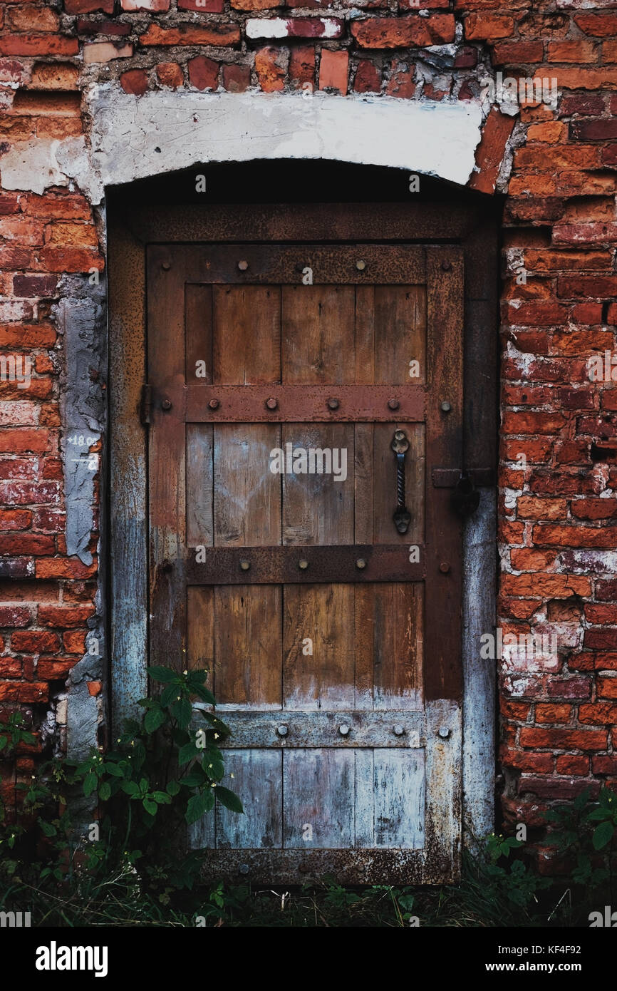 Old wooden door in a red face brick building. Close up view of ...