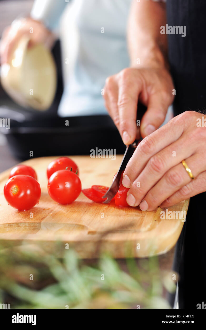 Woman slicing fresh tomatoes hi-res stock photography and images - Alamy