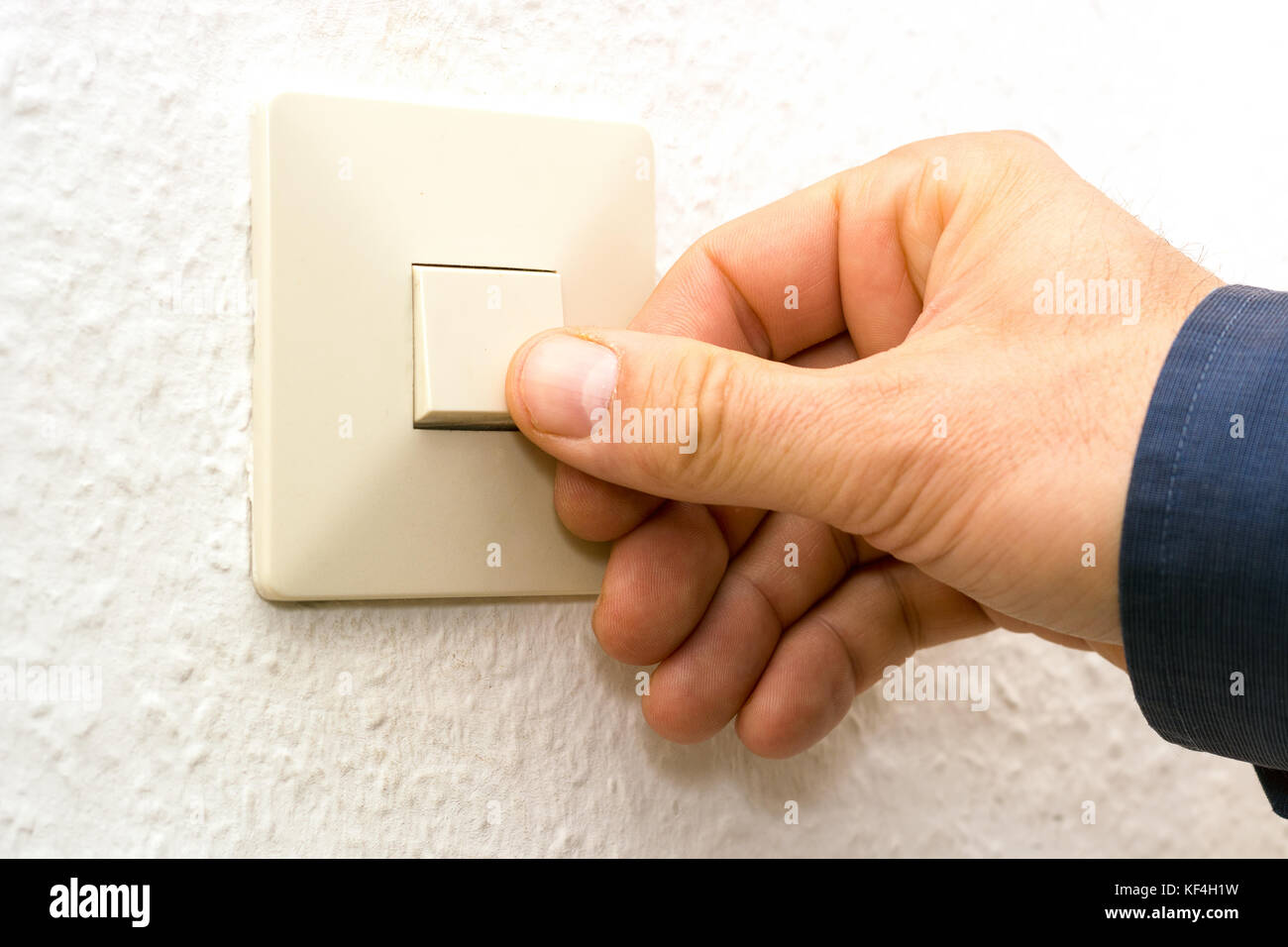 Men turning on white light switch Stock Photo - Alamy