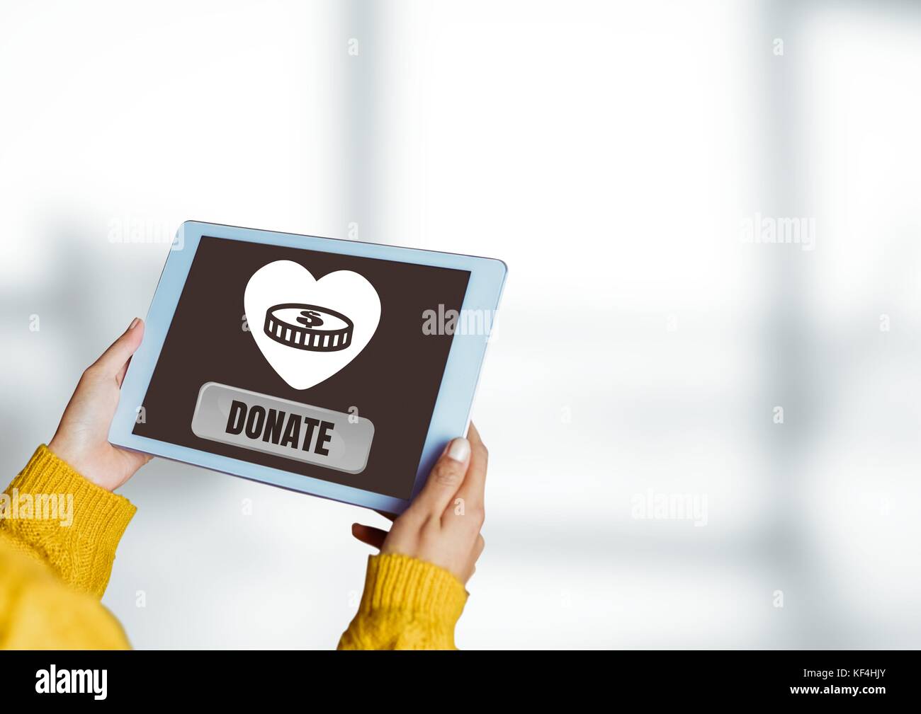 Digital composite of Hands holding tablet with Donate button and heart ...