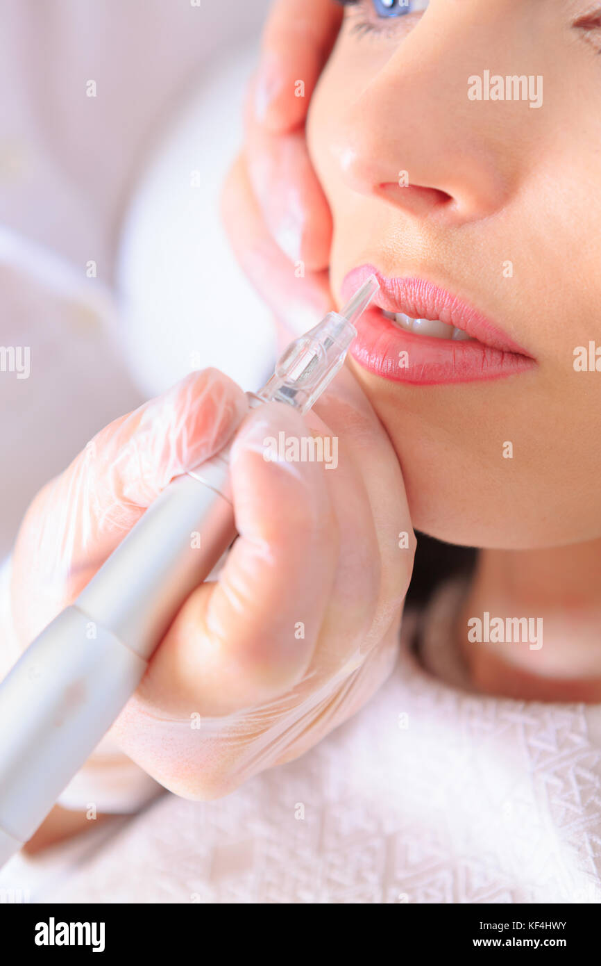 closeup of a female face by receiving of permanent makeup treatment at ...