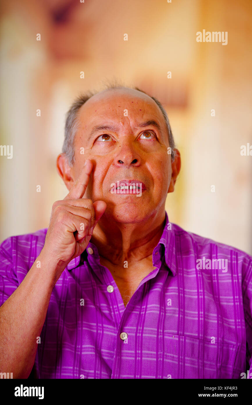 Portrait of a happy old man, pointing with his hand to somewhere ...