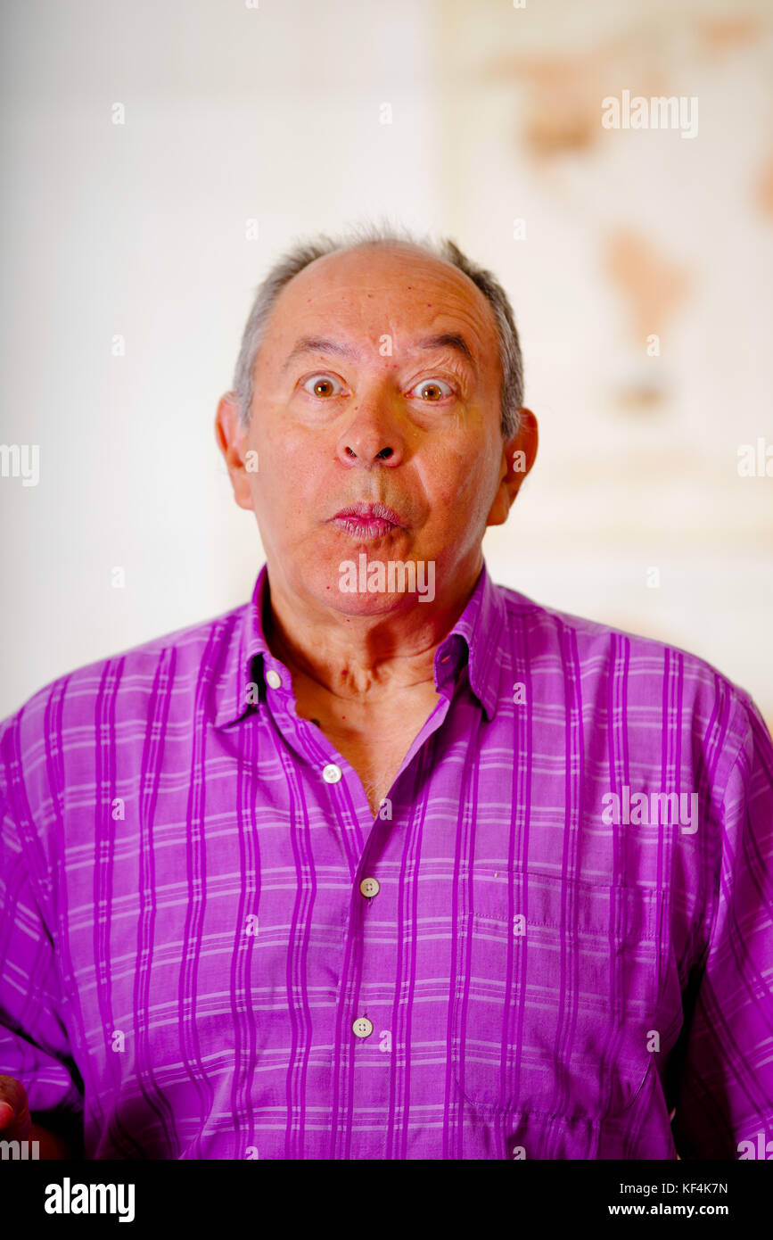 Portrait of a suprissed old man, doing a funny face and wearing a ...