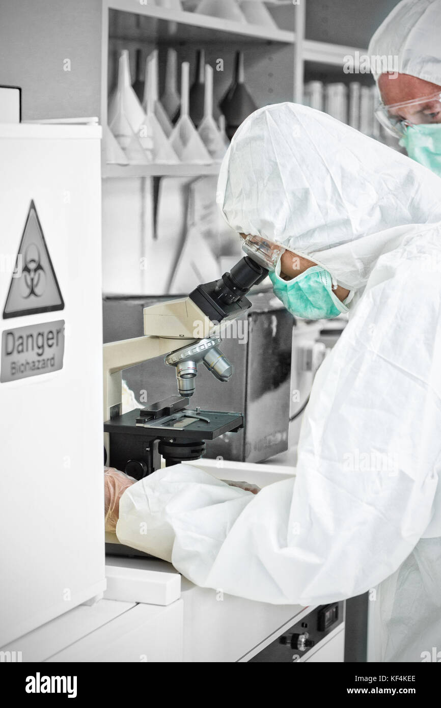 Scientist working on microscope Stock Photo - Alamy