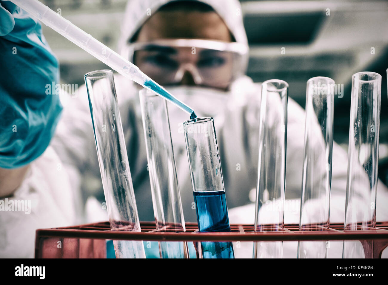 Close-up of science student dropping blue liquid in test tube in lab at ...