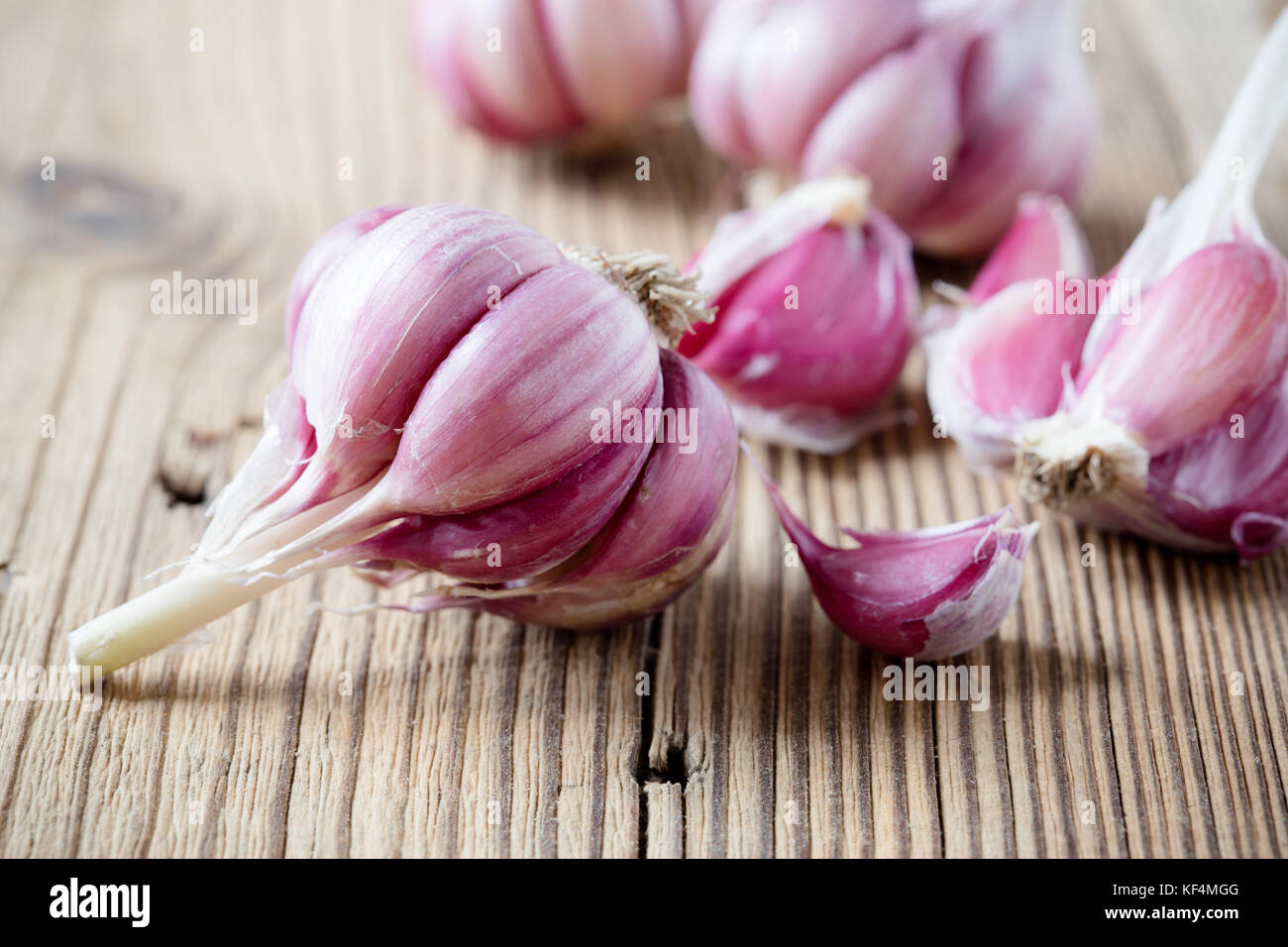 Head of garlic and purple cloves, organic raw purple garlic on wooden ...