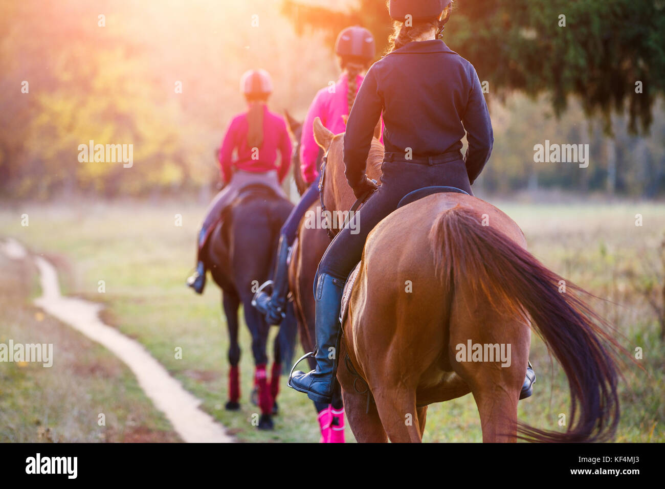 Group of teenage girls riding horses in autumn park. Equestrian sport ...