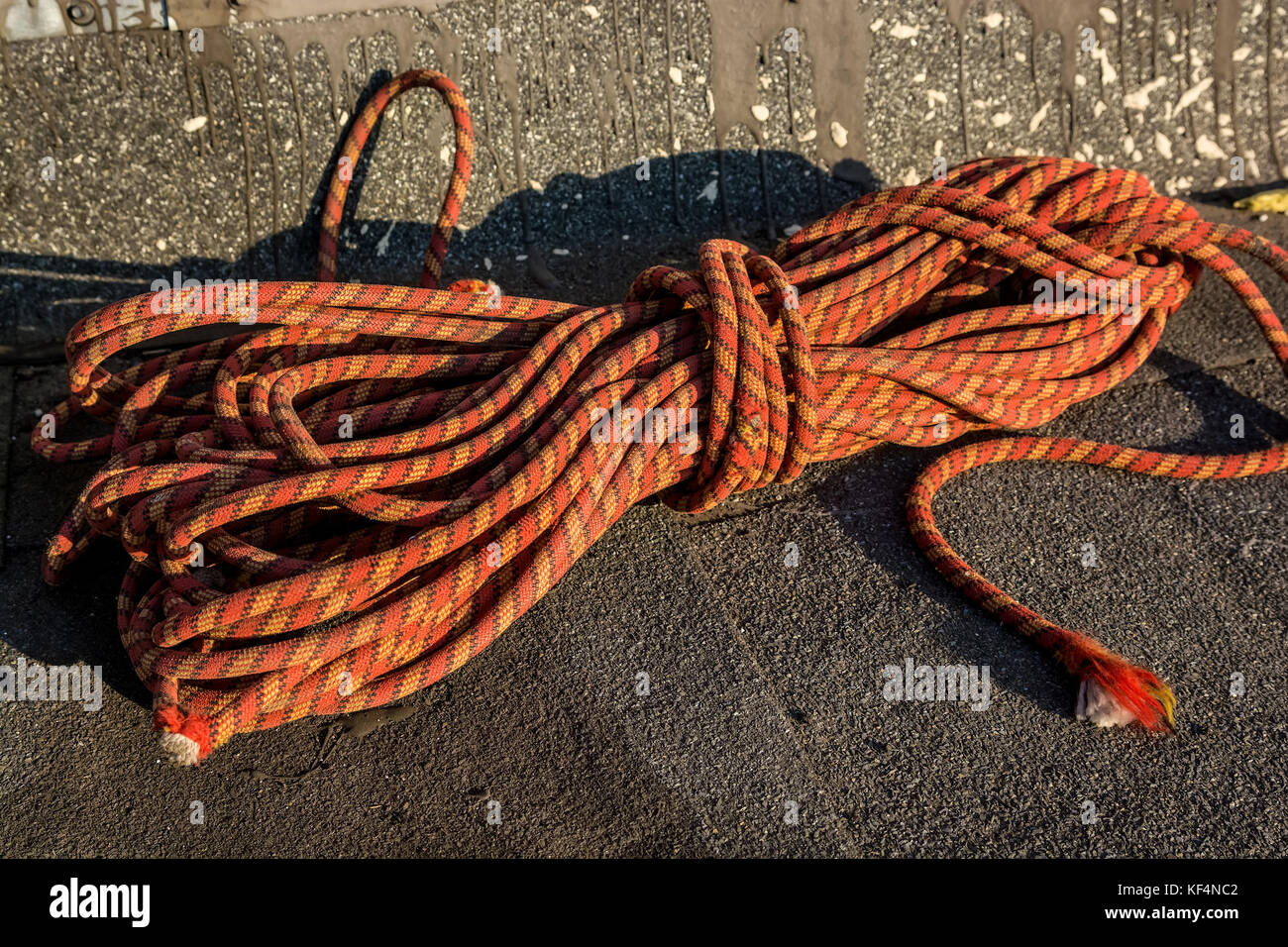 Close up image of coil of red and yellow industrial rope lying on ...