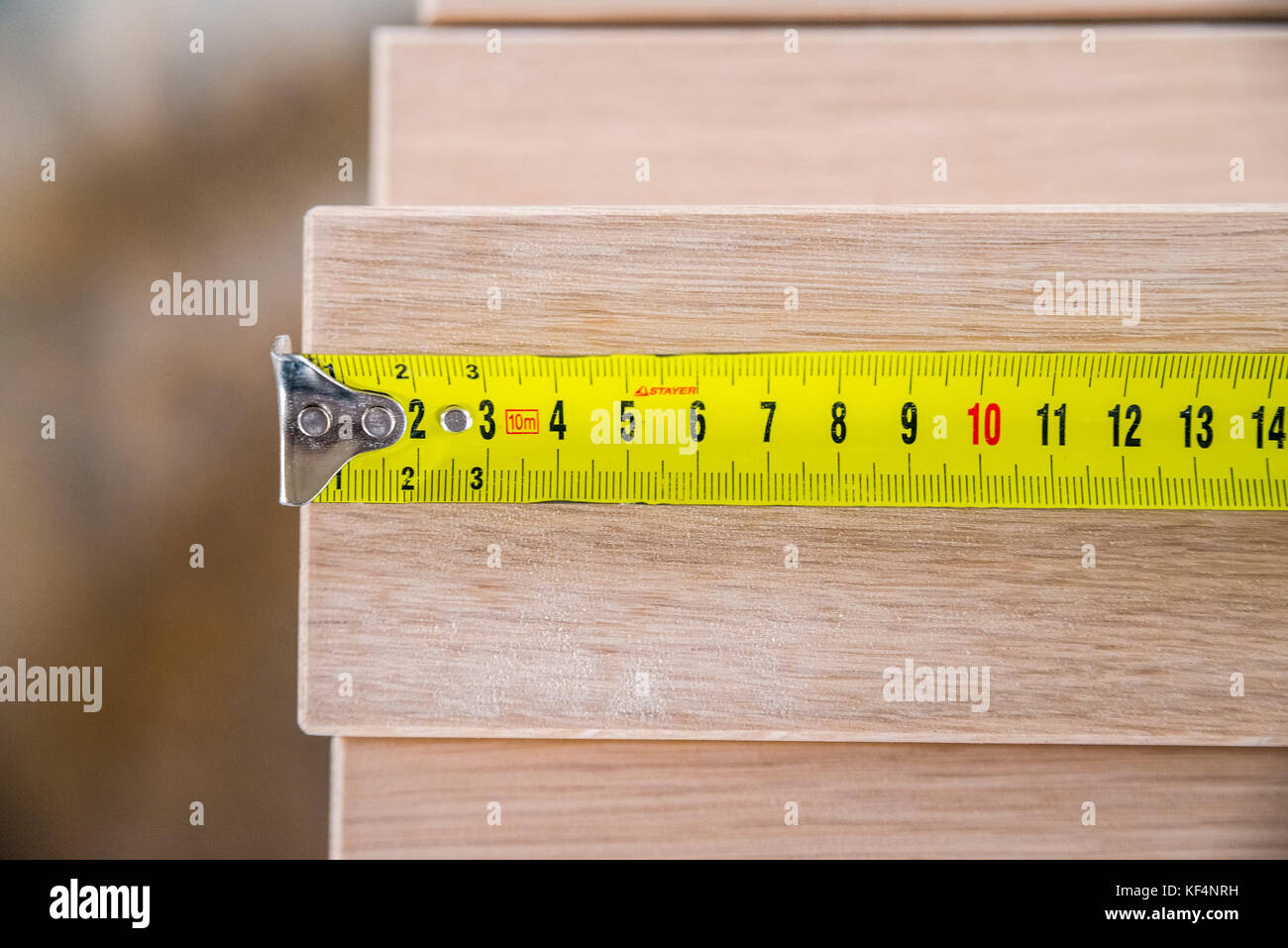 Close up self retracting tape measure on wooden plank Stock Photo - Alamy