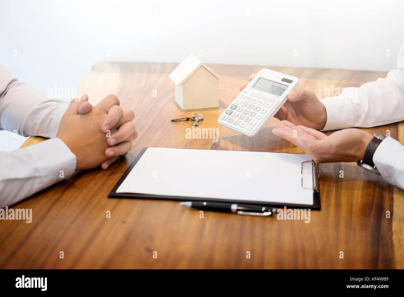 Real estate agent showing the purchase price on a calculator to ...