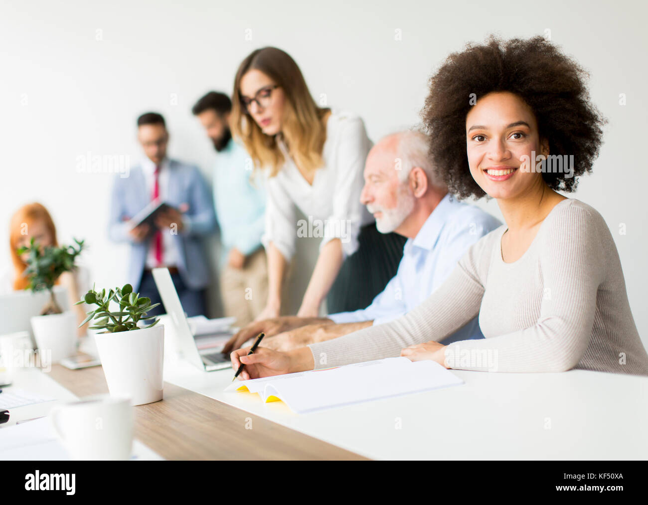View of multiracial business people around table during staff meeting ...