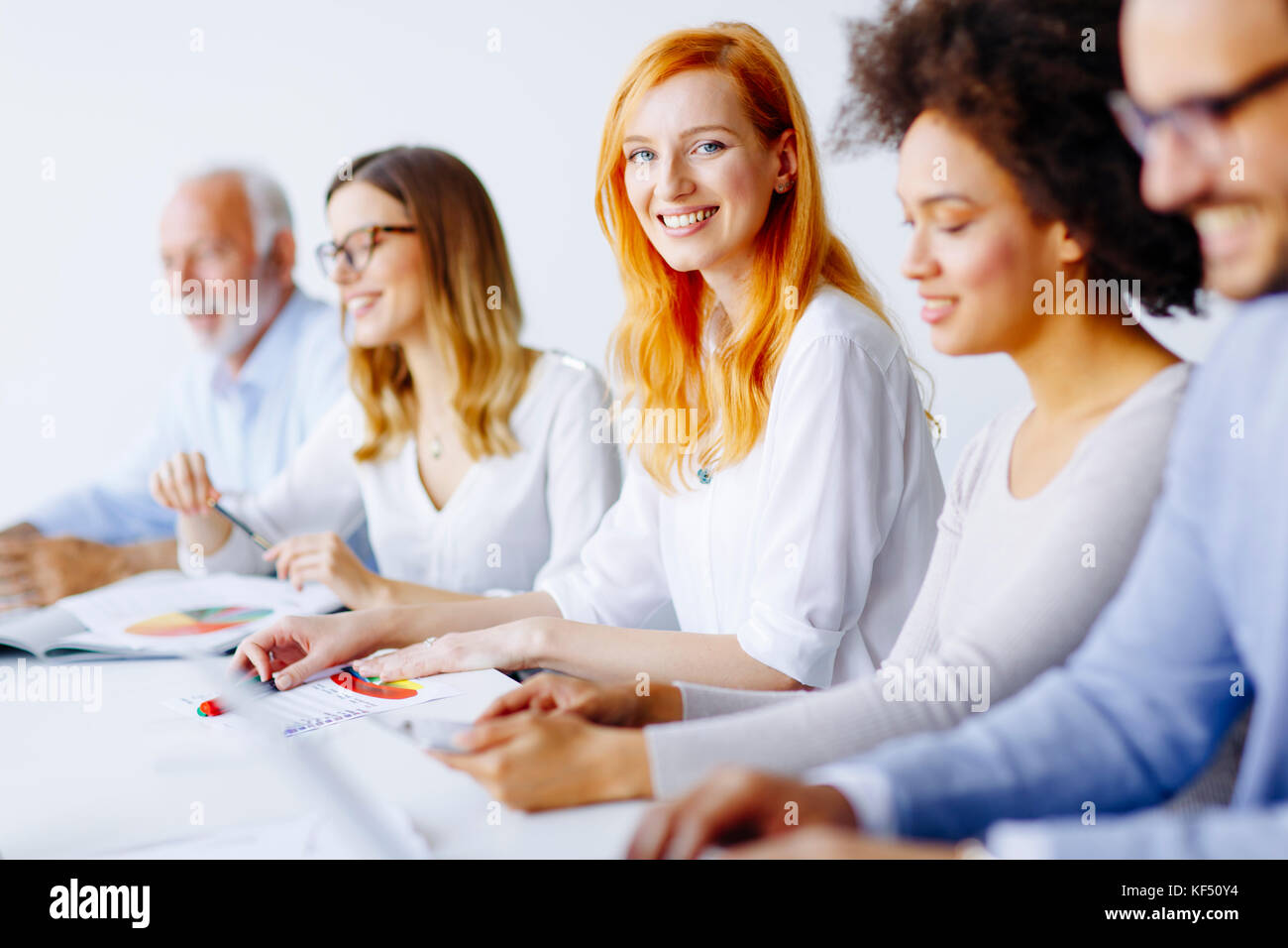View of multiracial business people around table during staff meeting ...