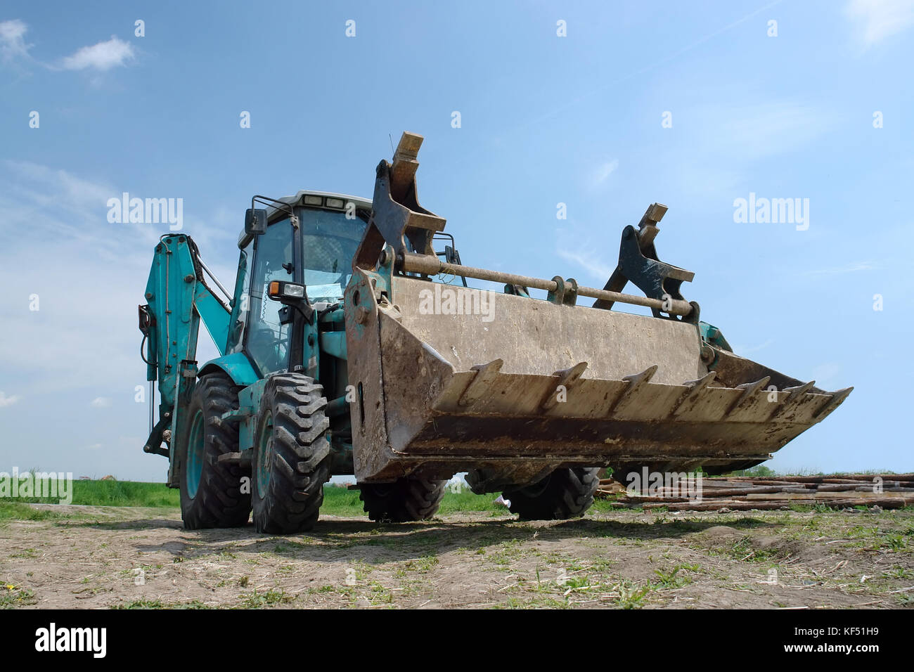Backhoe loader parked in the field - low perspective Stock Photo - Alamy