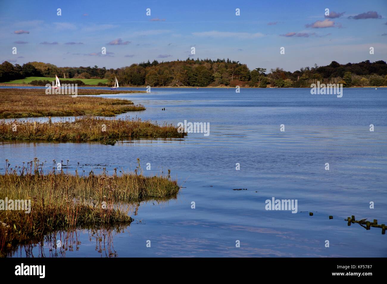 Boats and reflections in the shiny River Deben on a bright sunny ...