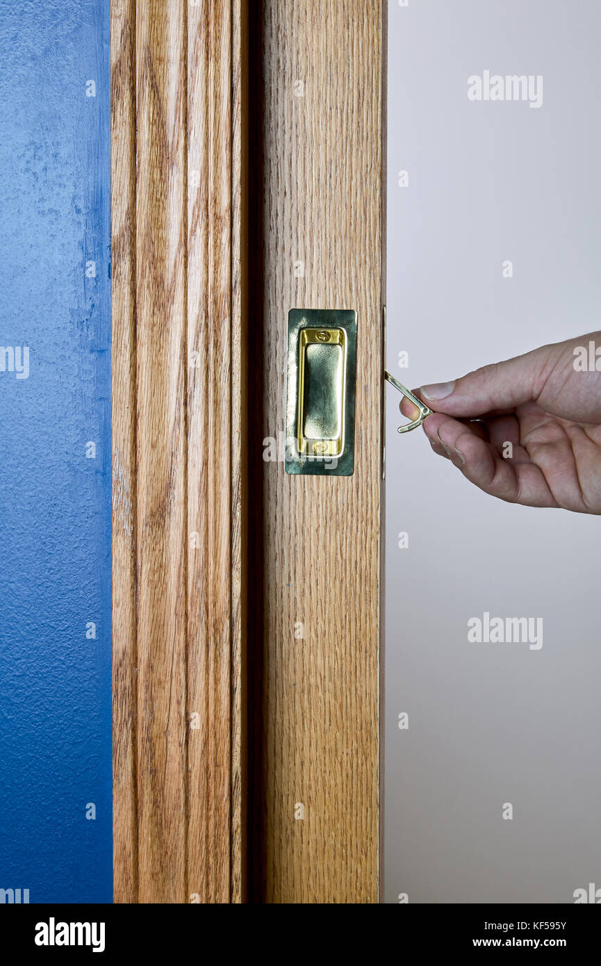 Someone using their hand and lifting a small metal lever in wooden ...