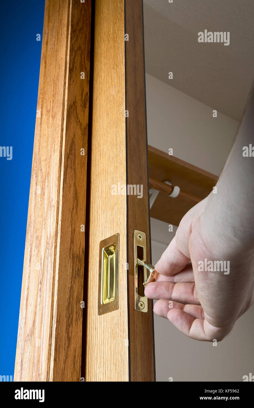 Open pocket door with male hand holding the pull edge lever on the ...