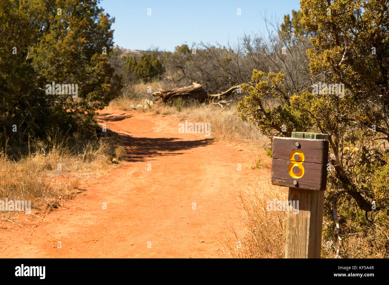 A red, dry desert hiking trail and distance marker sign post in Palo ...