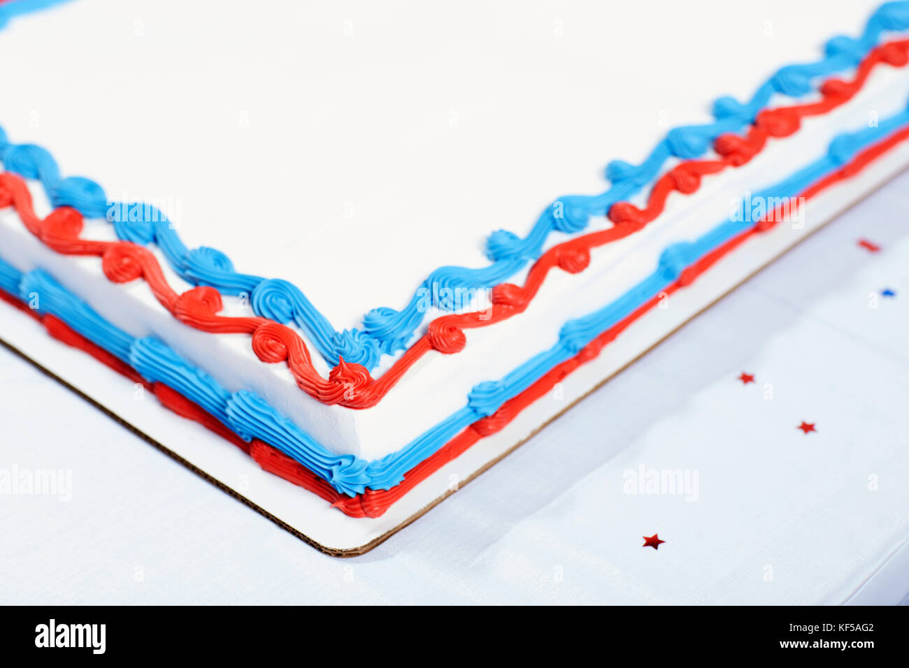 High-angle close-up of the corner of a white rectangular birthday cake ...