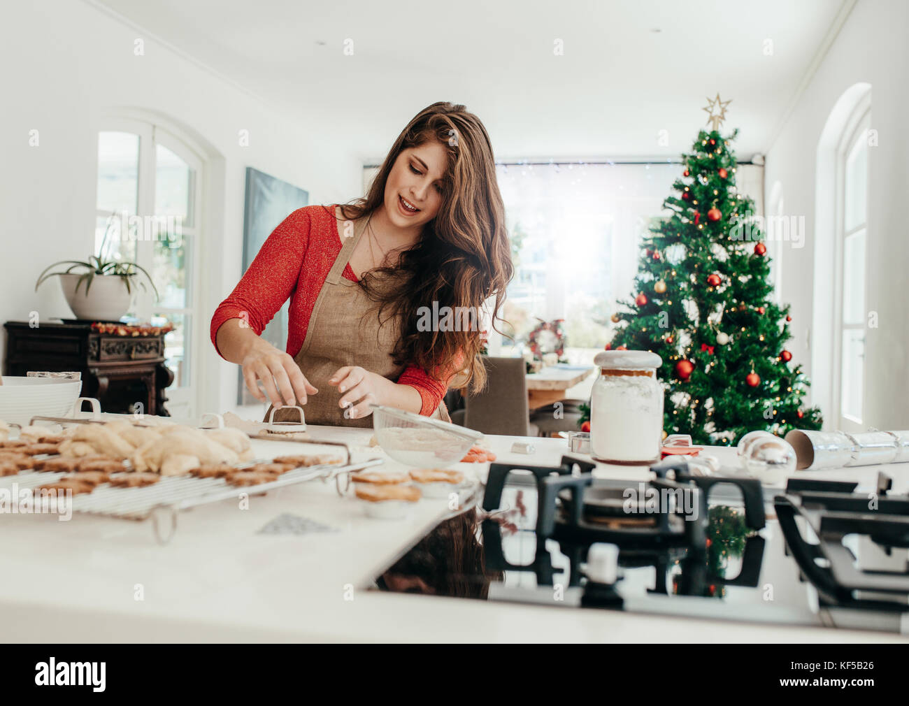 Young woman making shaped cookies with cutter for Christmas. Living ...