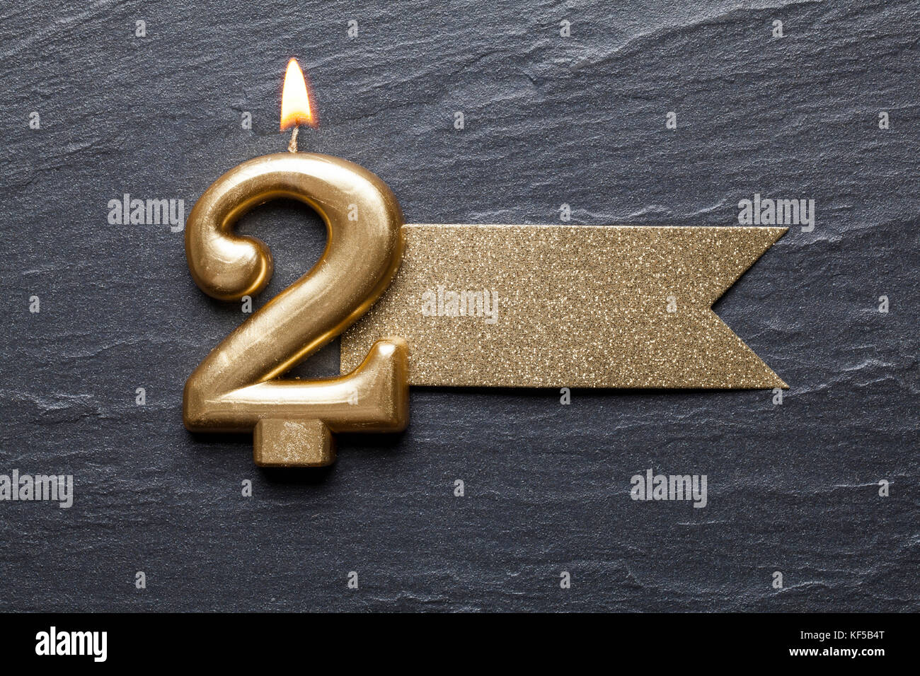 Gold number 2 celebration candle with glitter label Stock Photo - Alamy
