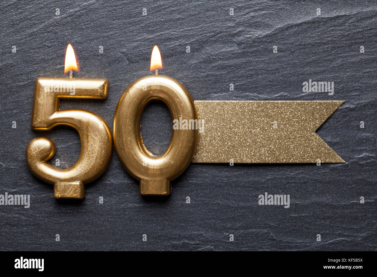 Gold number 50 celebration candle with glitter label Stock Photo - Alamy