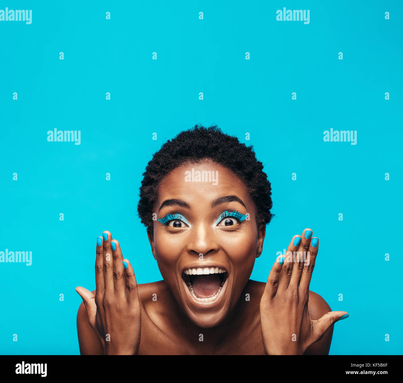 Excited young woman with vibrant eye shadow and nail paint. Female ...