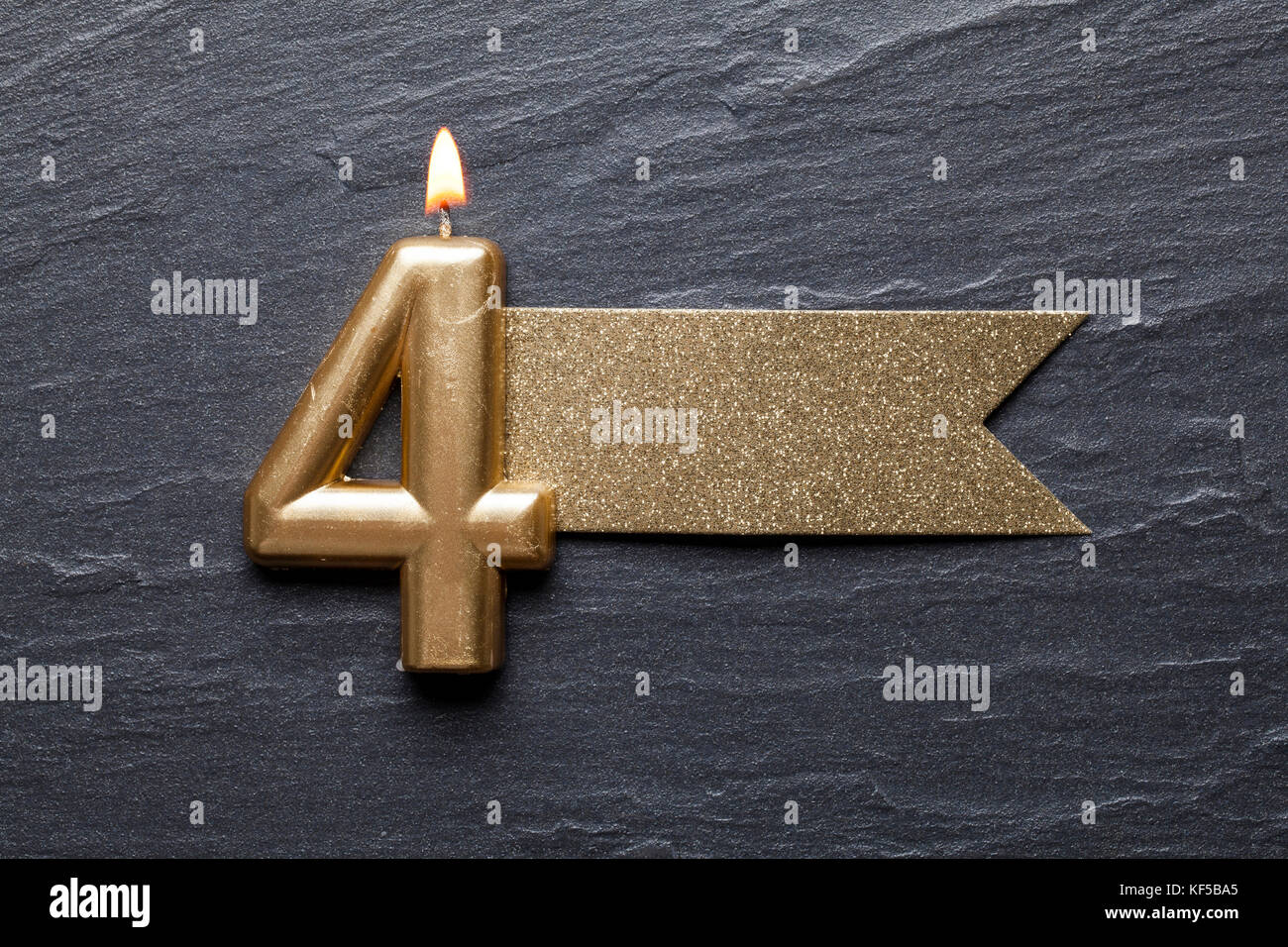 Gold number 4 celebration candle with glitter label Stock Photo - Alamy