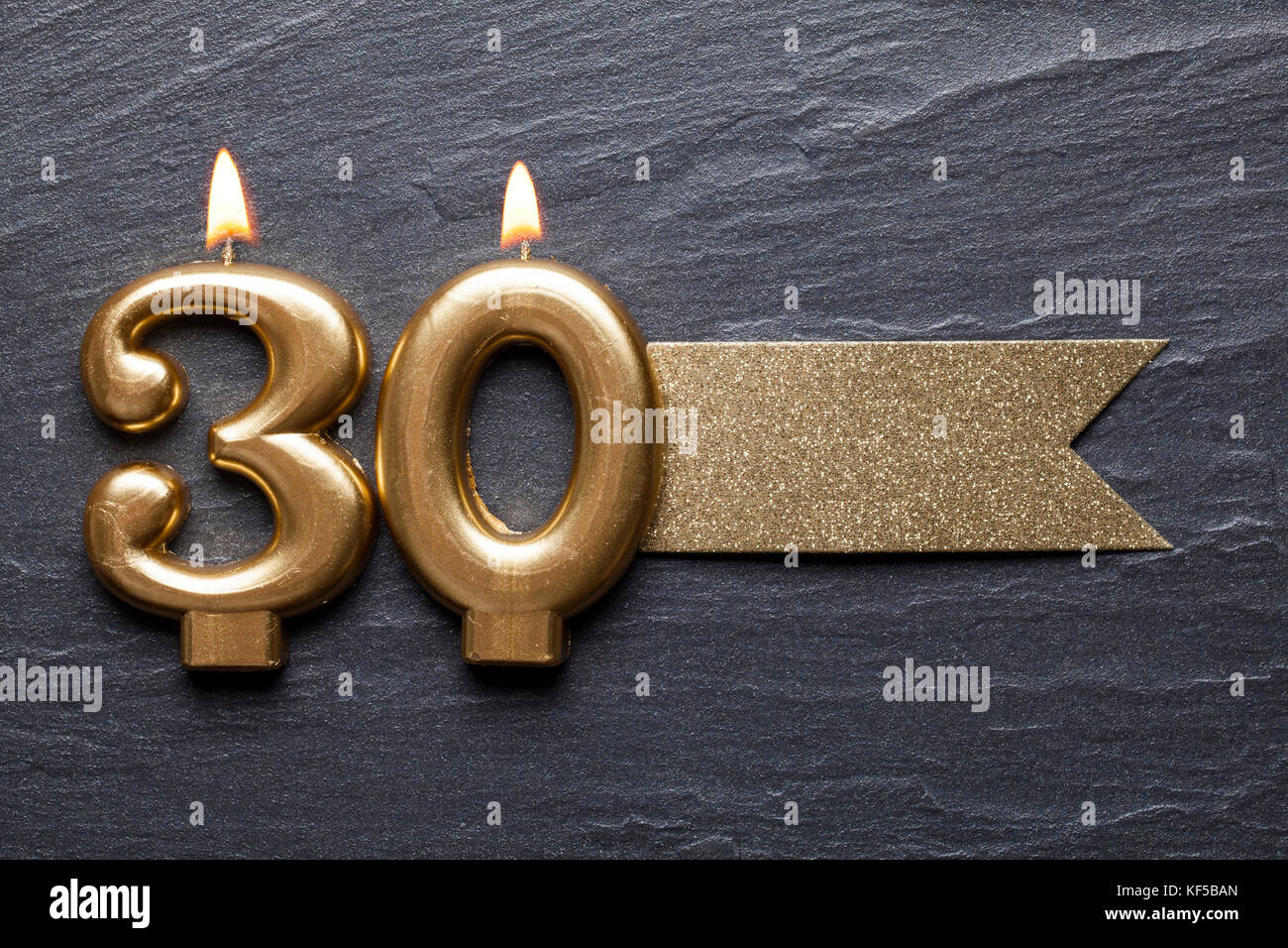 Gold number 30 celebration candle with glitter label Stock Photo - Alamy