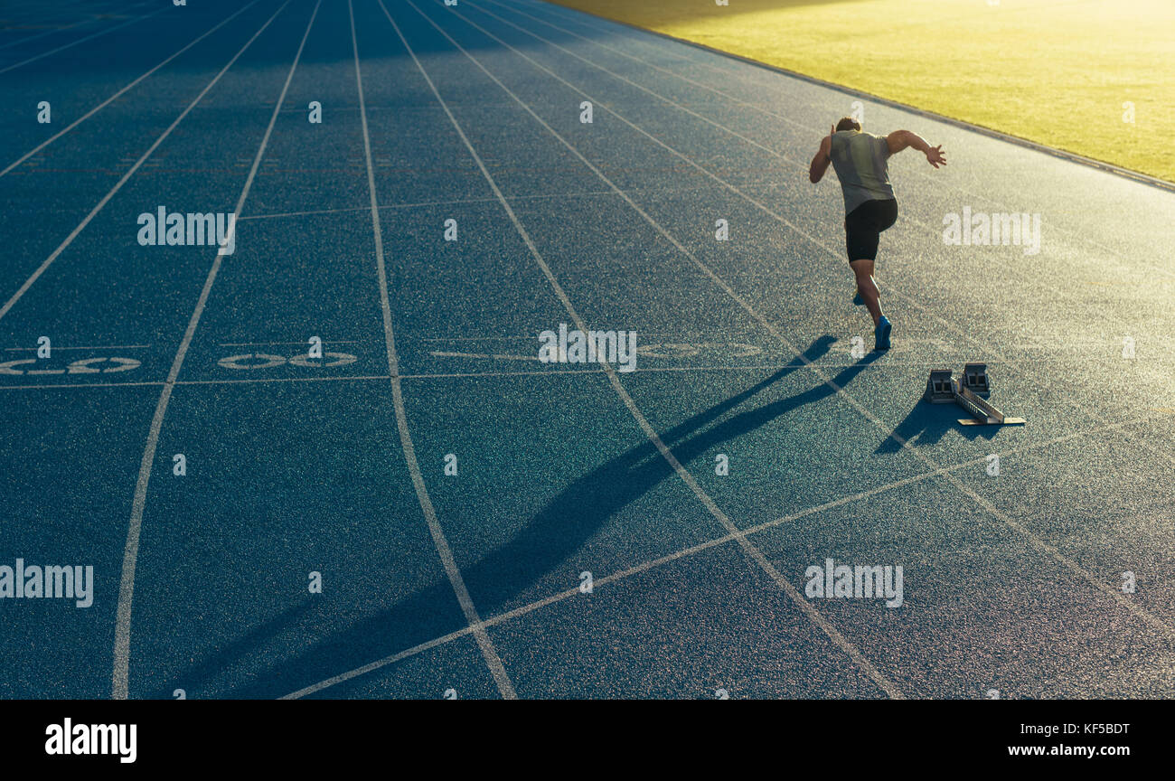 Athlete running on an all-weather running track alone. Runner sprinting ...