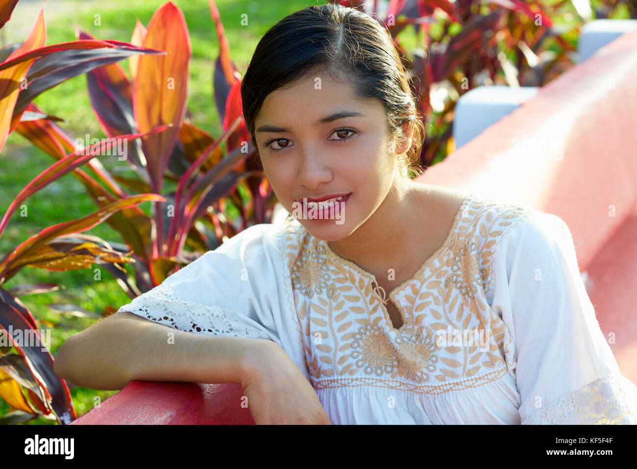 Mexican latin woman with ethnic dress sitting in garden park bench ...