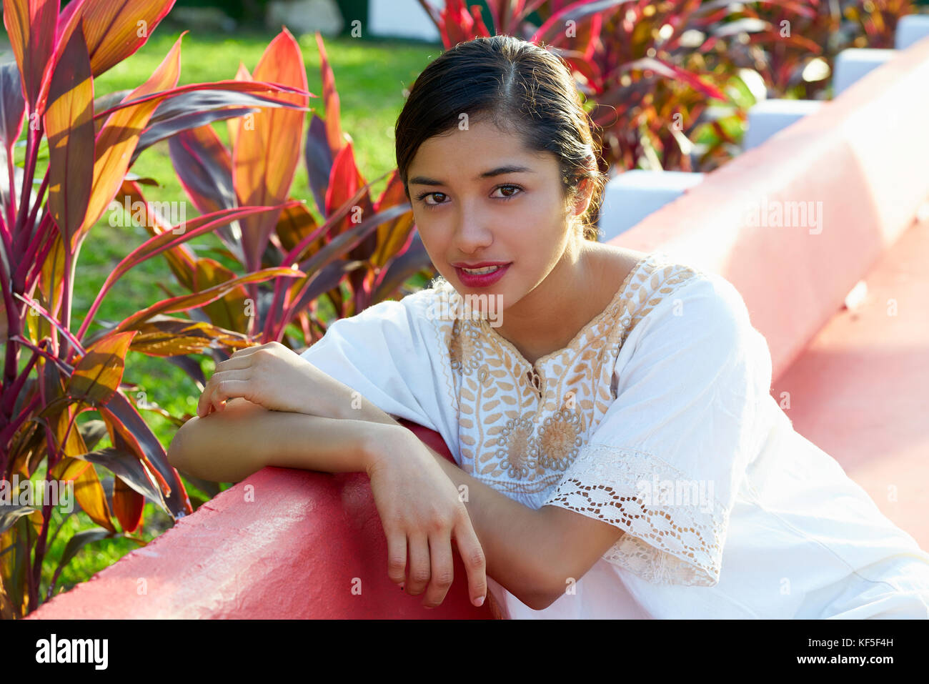 Mexican latin woman with ethnic dress sitting in garden park bench ...