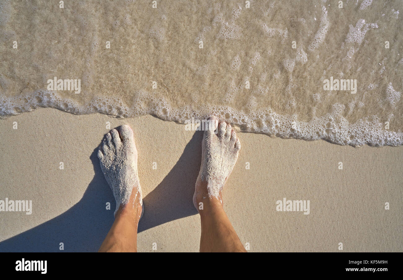 Caribbean tourist male feet on white sand shore wave foam vacation ...