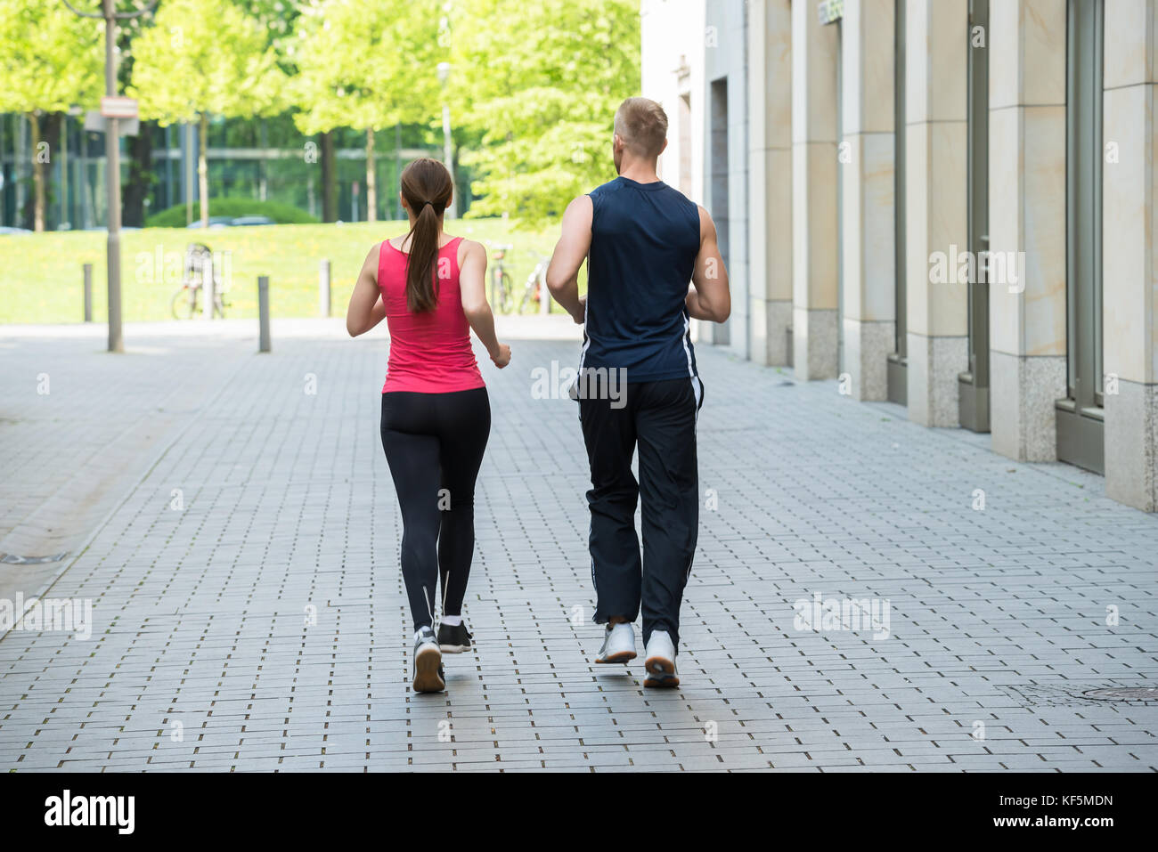 Rear View Of Young Couple Running Together Stock Photo - Alamy