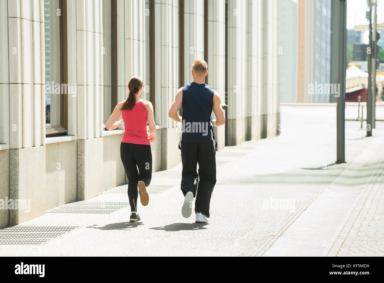 Rear View Of Young Couple Running Together Stock Photo - Alamy
