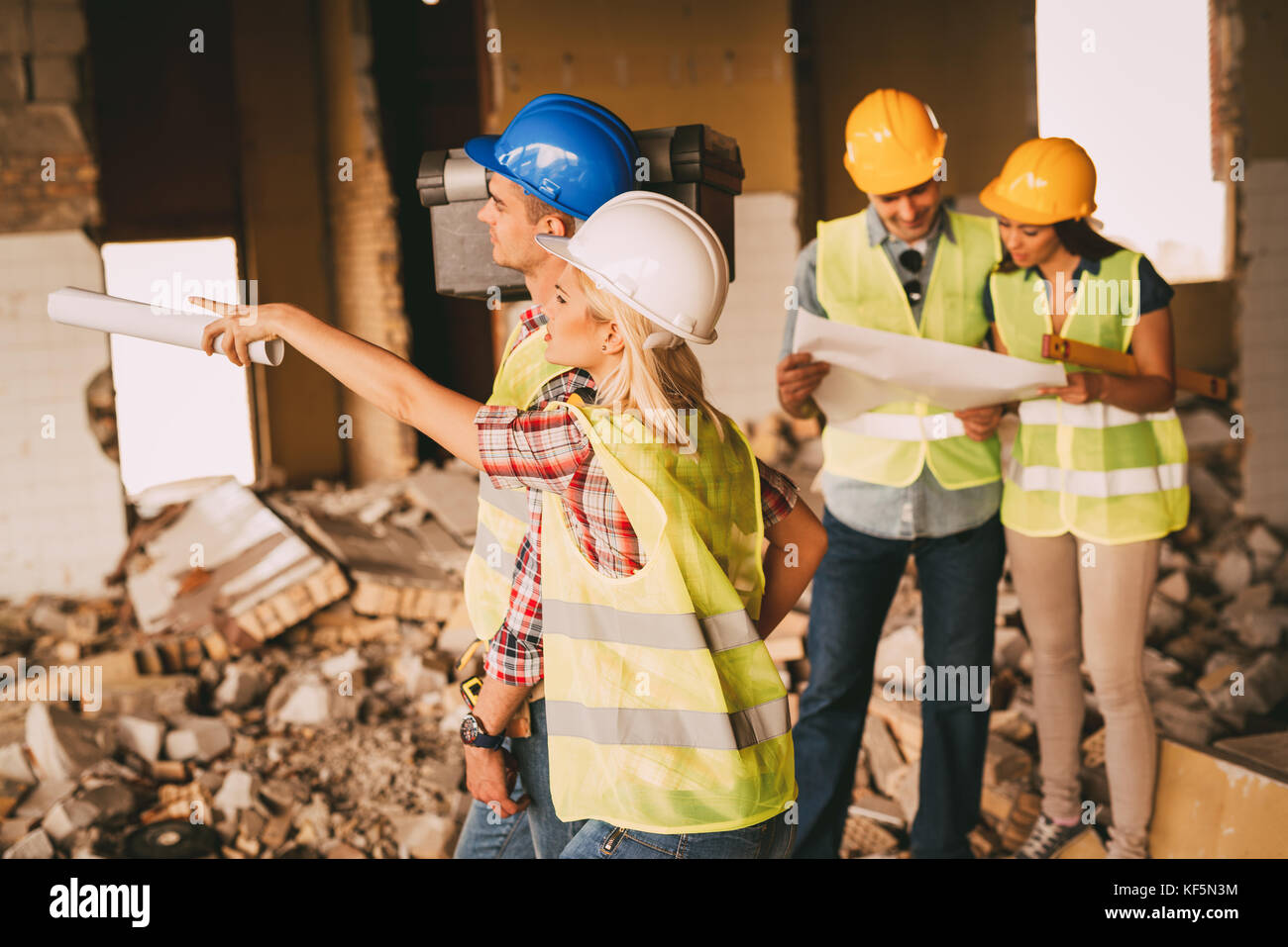 Four construction architects review plans of building damaged in the ...