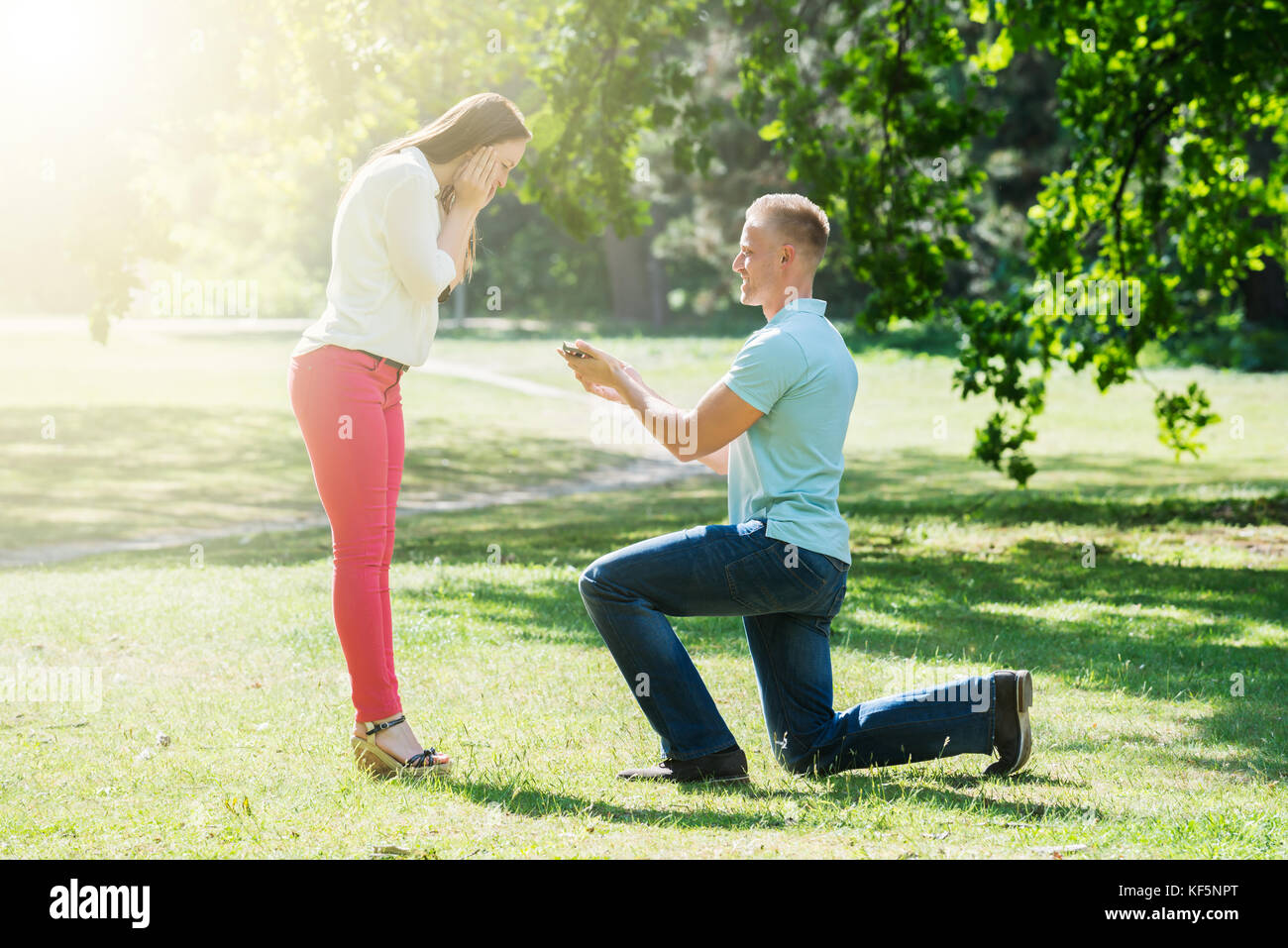 Man Kneeling And Making Proposal To Woman At Park Stock Photo - Alamy