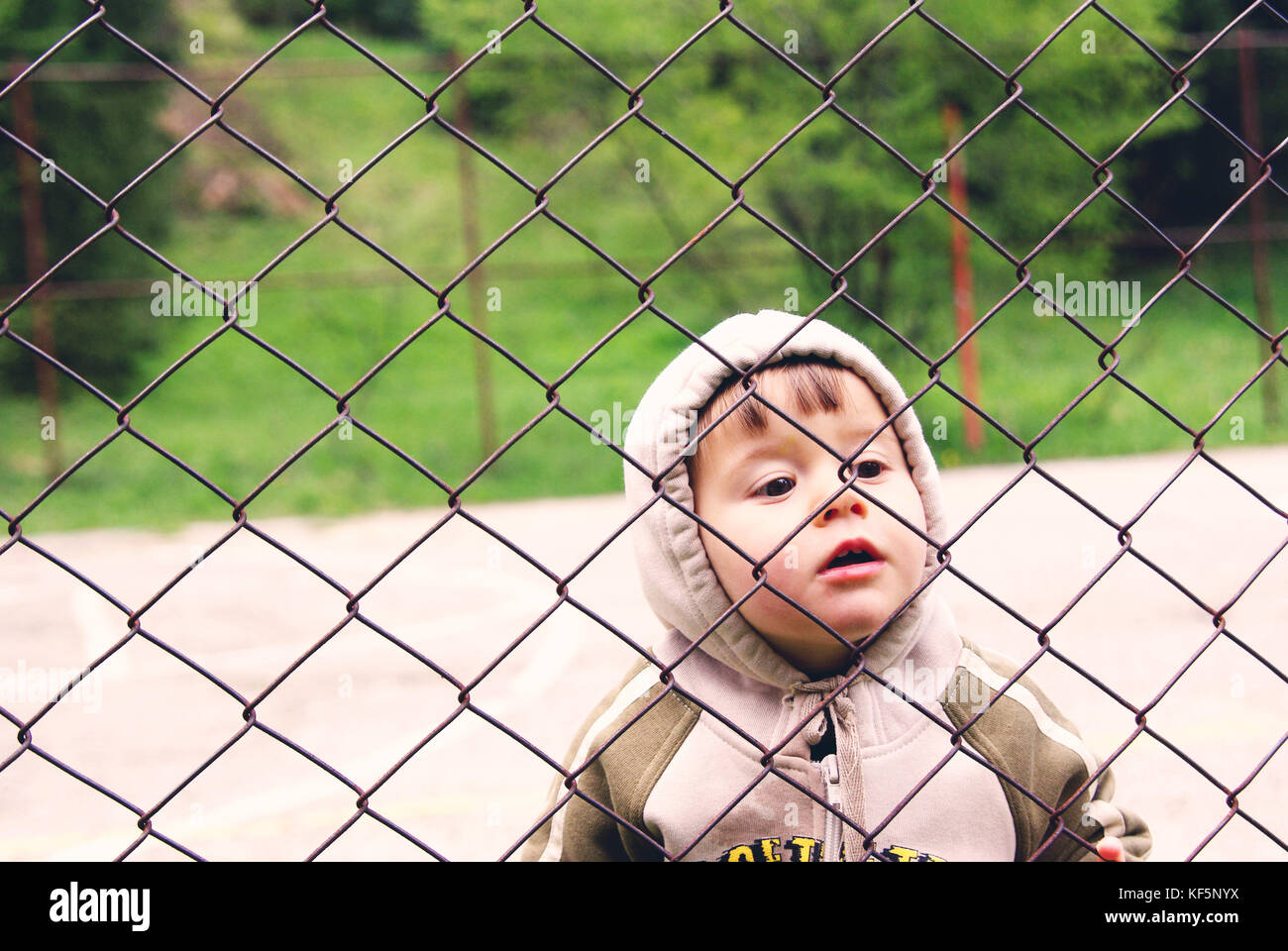 Boy behind wire fence hi-res stock photography and images - Alamy