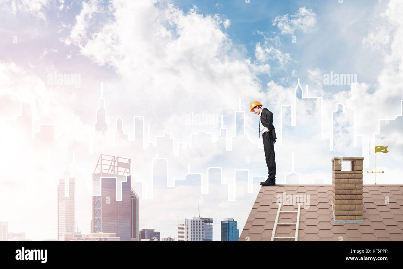 Engineer man standing on roof and looking down. Mixed media Stock Photo ...