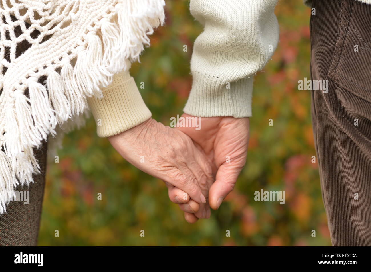 Elderly couple holding hands Stock Photo - Alamy