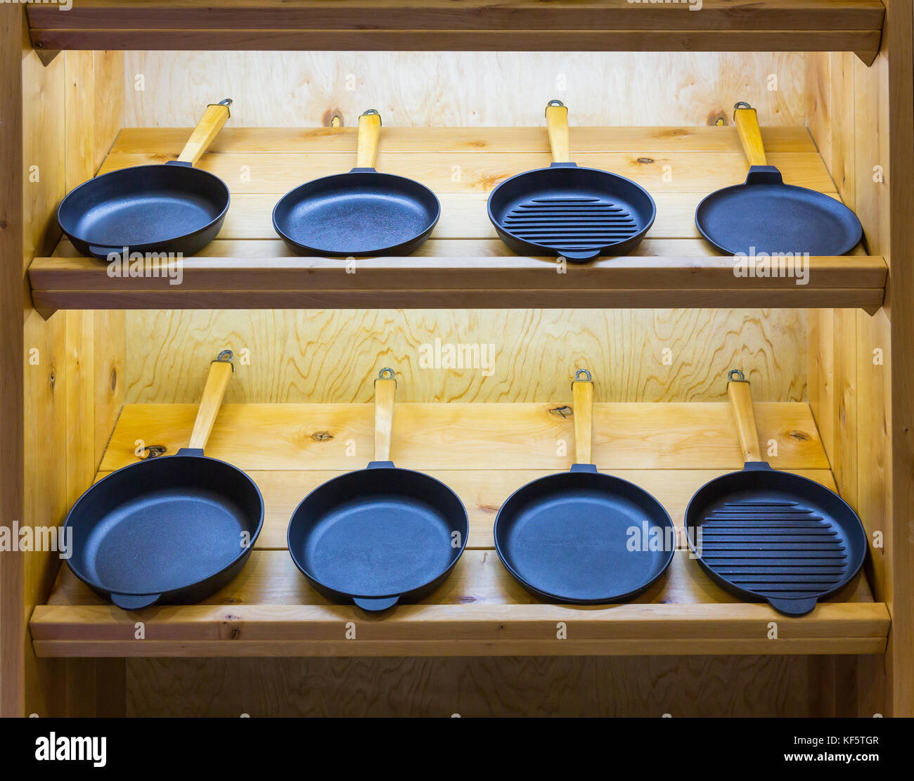 Frying pans on wooden shelf, cooking tools Stock Photo - Alamy