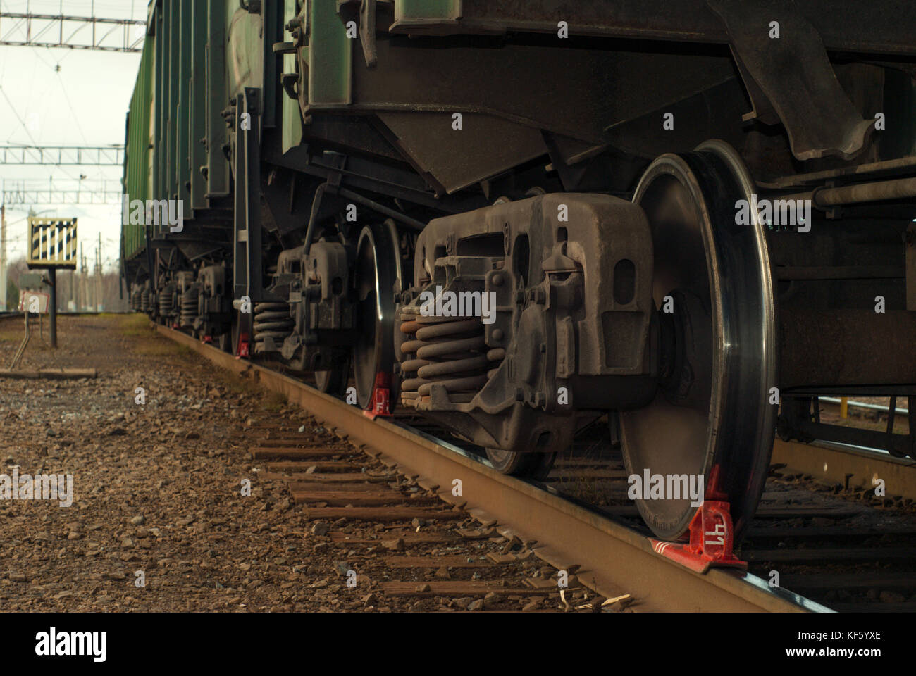 A bogie of freight railcar closeup, with brake shoe put under the wheel ...