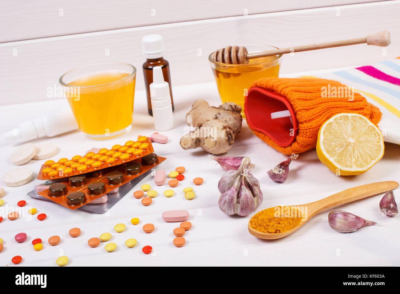 Medical pills, hot water bottle and ingredients for preparation warming ...